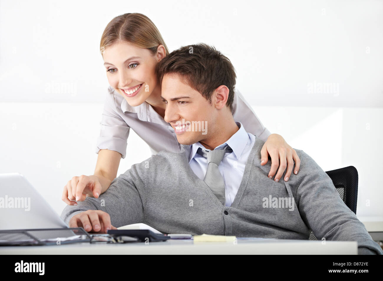 Two happy students working at laptop computer in the university Stock ...
