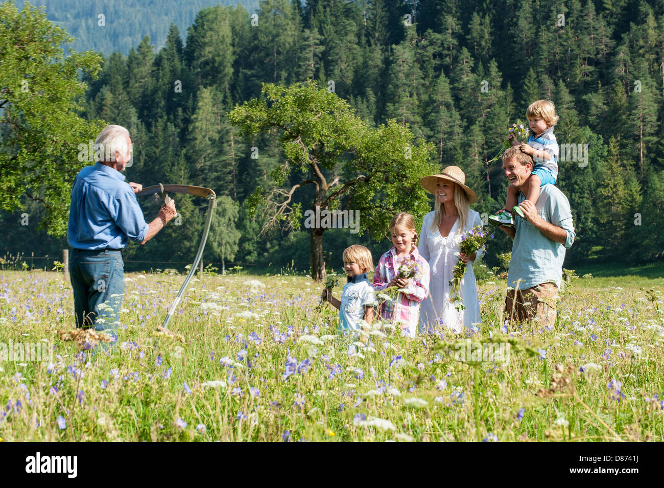Germany, Salzburg, Farmer and family in summer meadow, smiling Stock ...