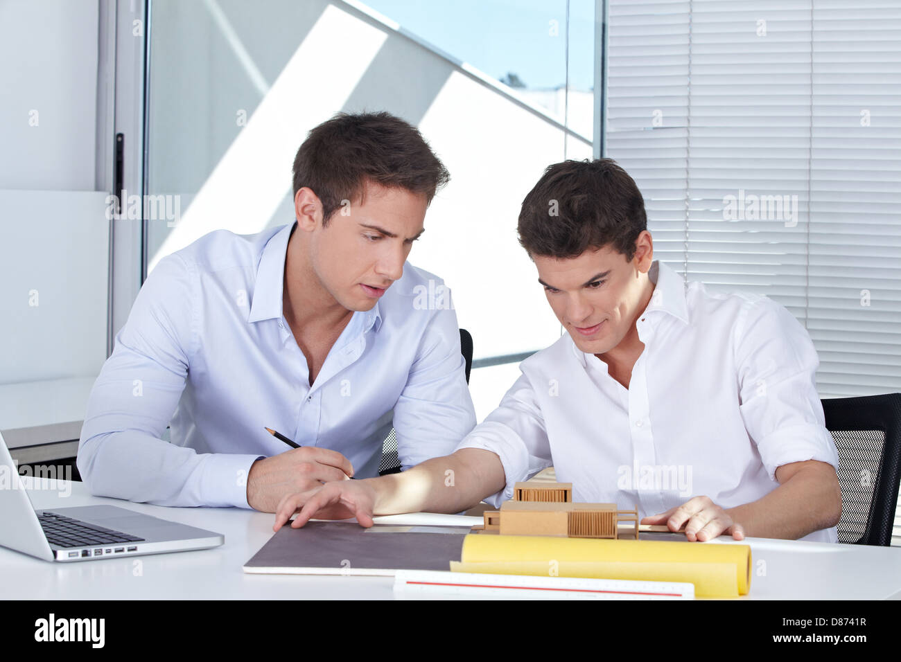 Two students at their desk with building model and laptop computer ...