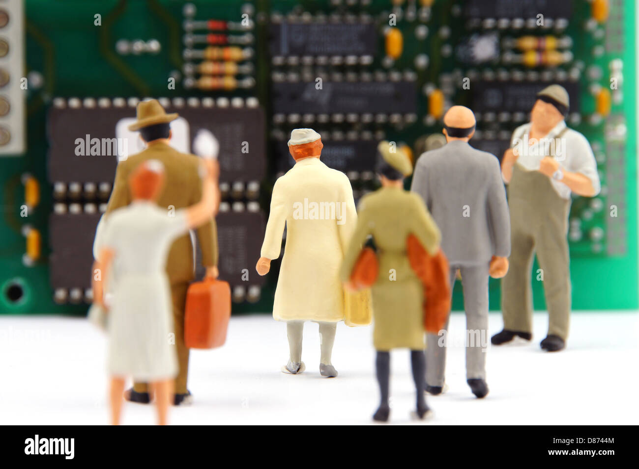 Minature figurines in front of computer board Stock Photo - Alamy