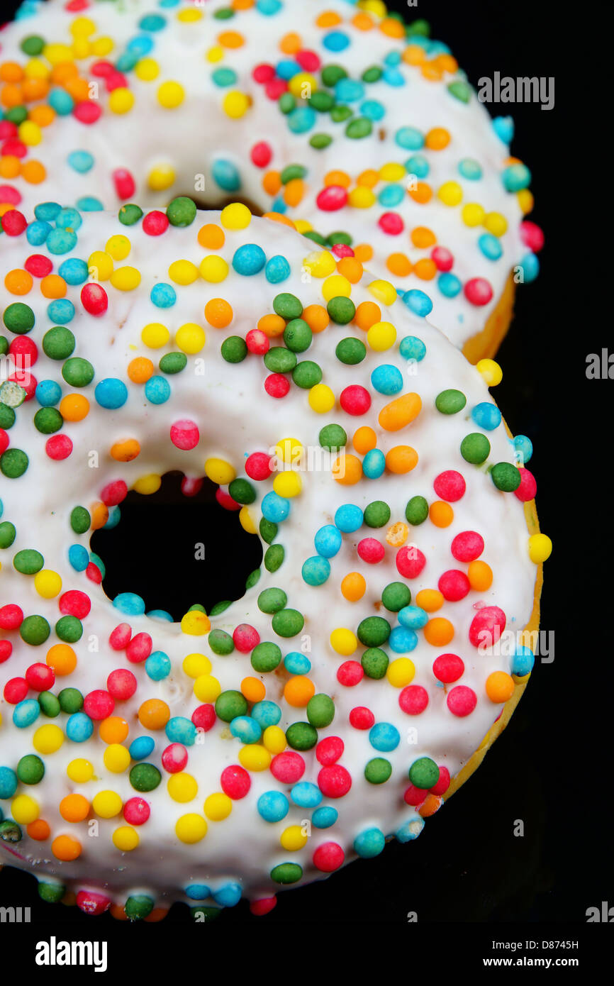 Donuts with multi coloured sugar pearls on white background Stock Photo ...