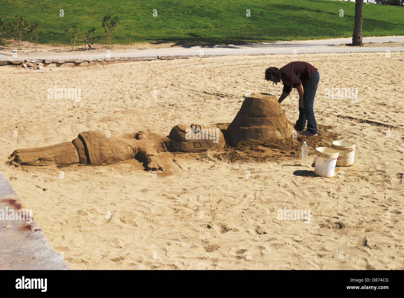 Artist making sand sculpture of Homer Simpson on Barceloneta Beach ...