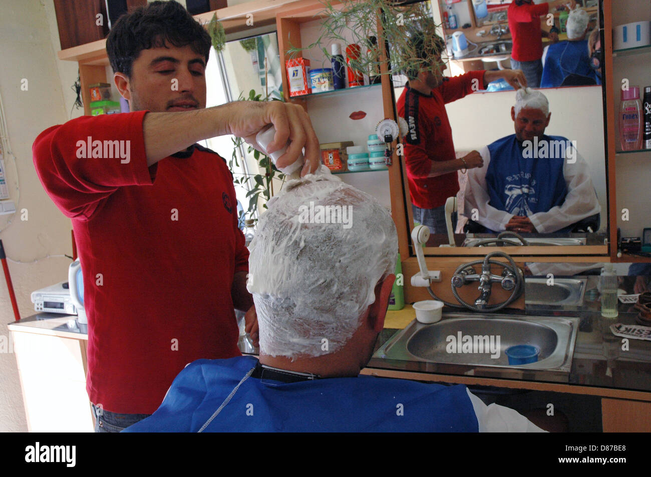 Barber shaving and grooming men in Turkish village barber shop Stock ...