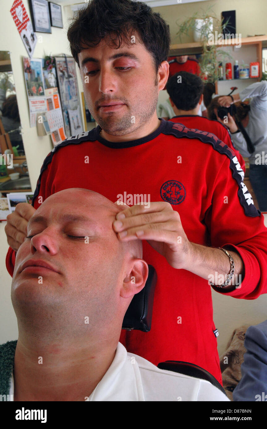 Barber shaving and grooming men in Turkish village barber shop Stock ...