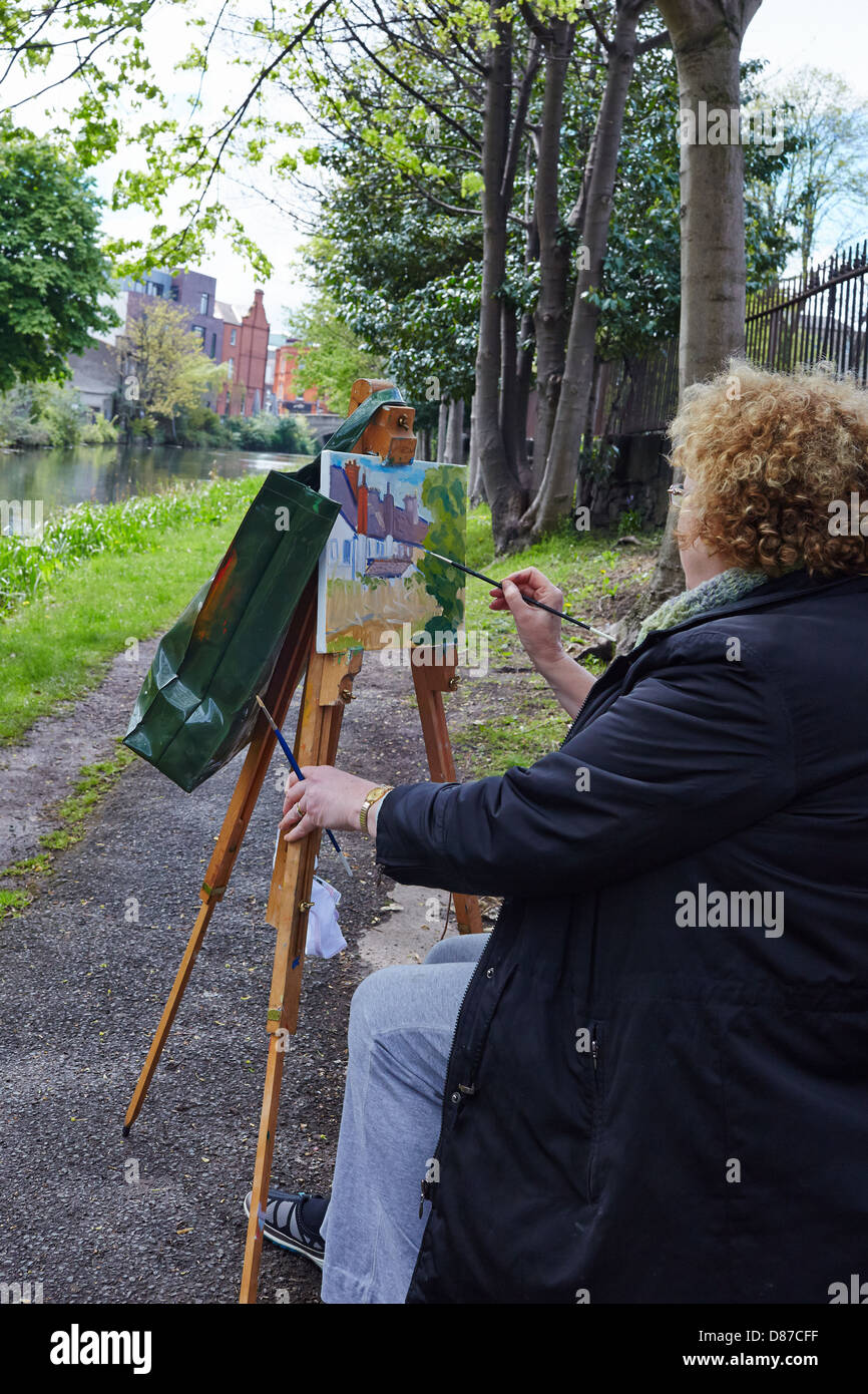 Woman painting a scenic view on the Grand Canal tow path, Dublin ...