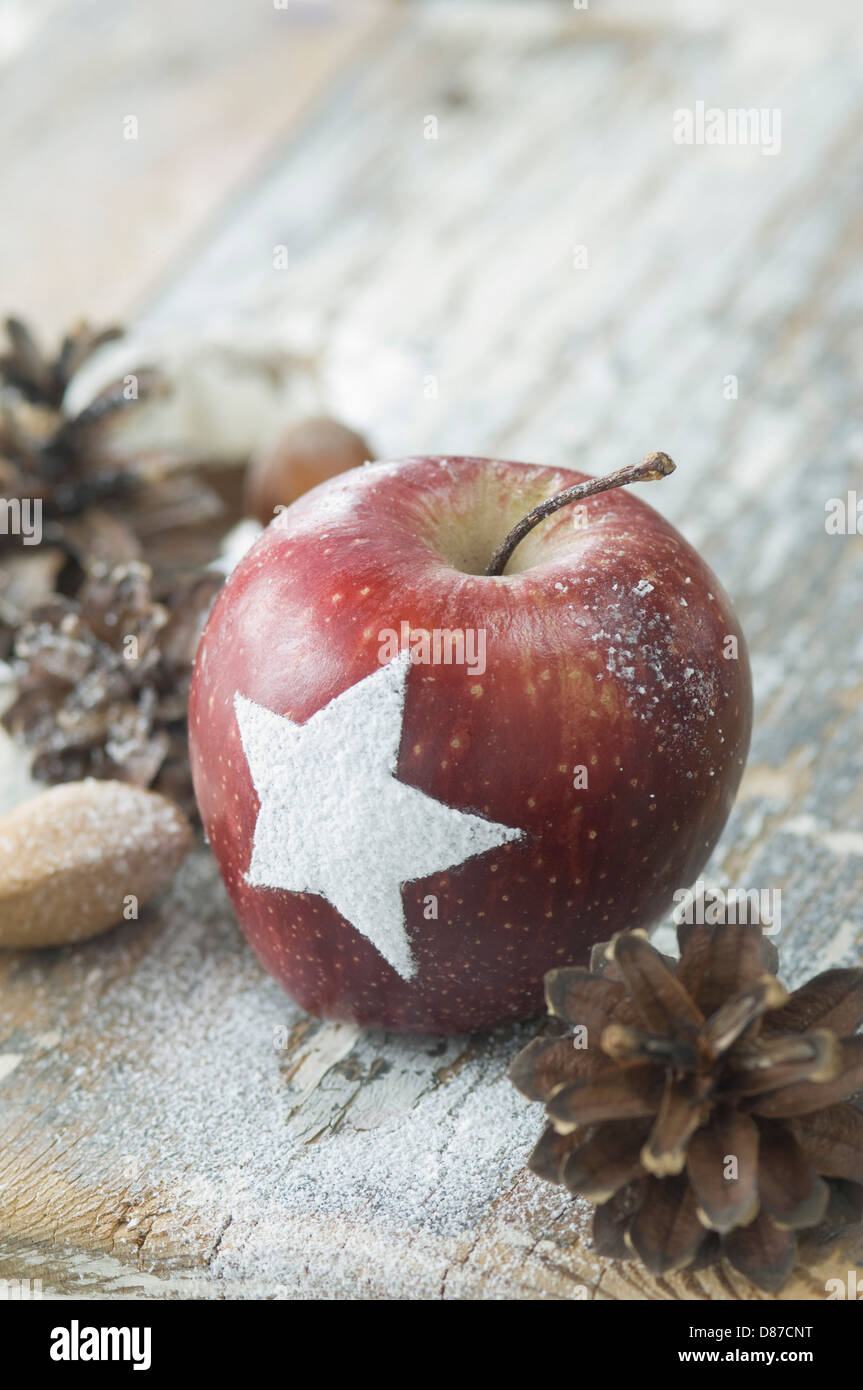 Christmas apple with snow star, pine cones, almonds and hazelnuts on ...