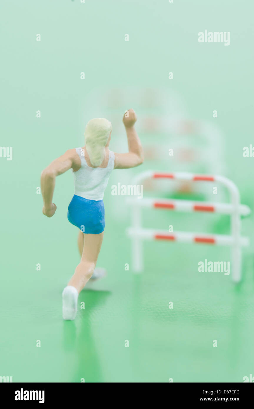 Figurine woman running in front of hurdles Stock Photo - Alamy