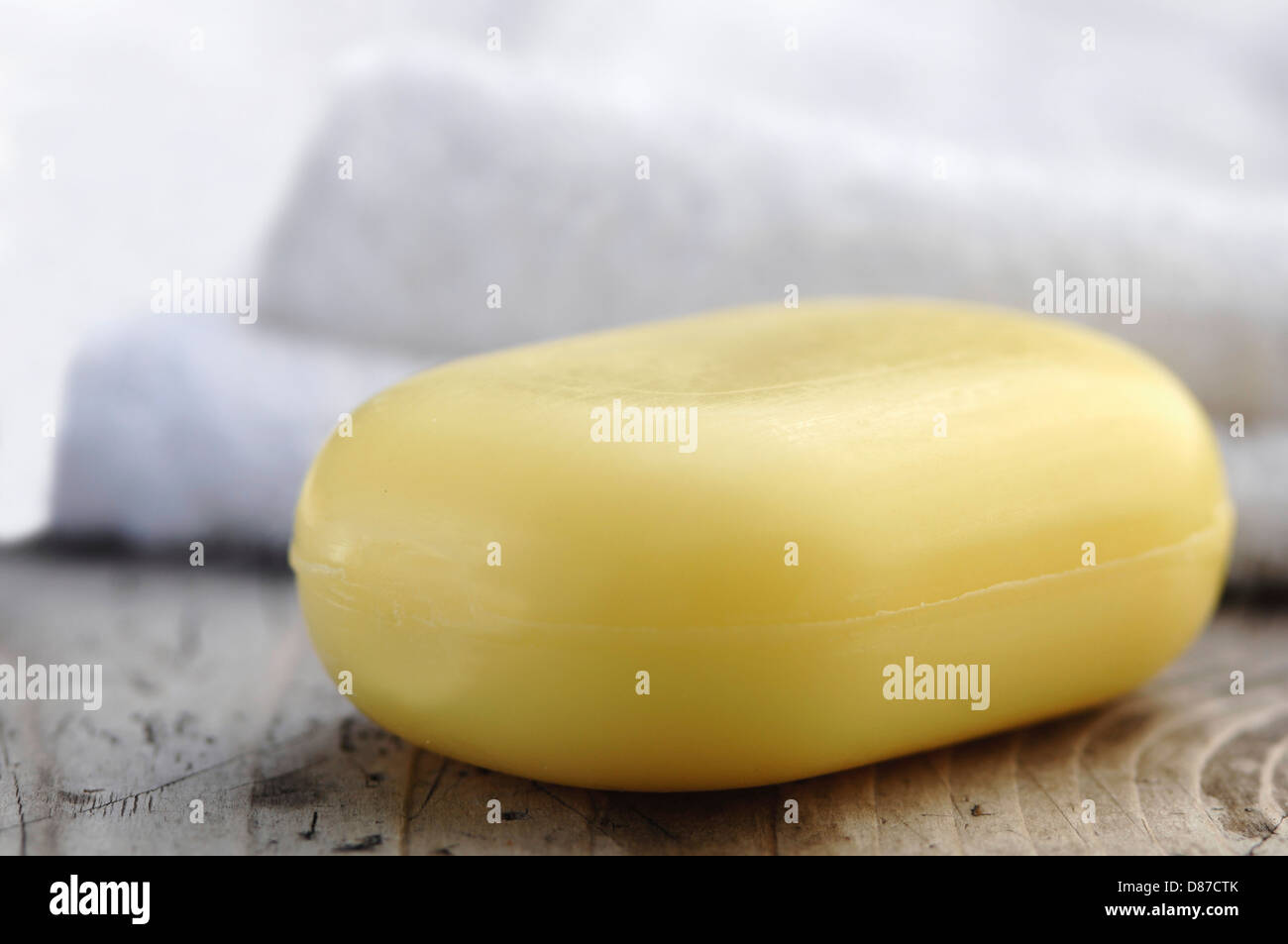 Bar of soap with towel on wooden table Stock Photo - Alamy