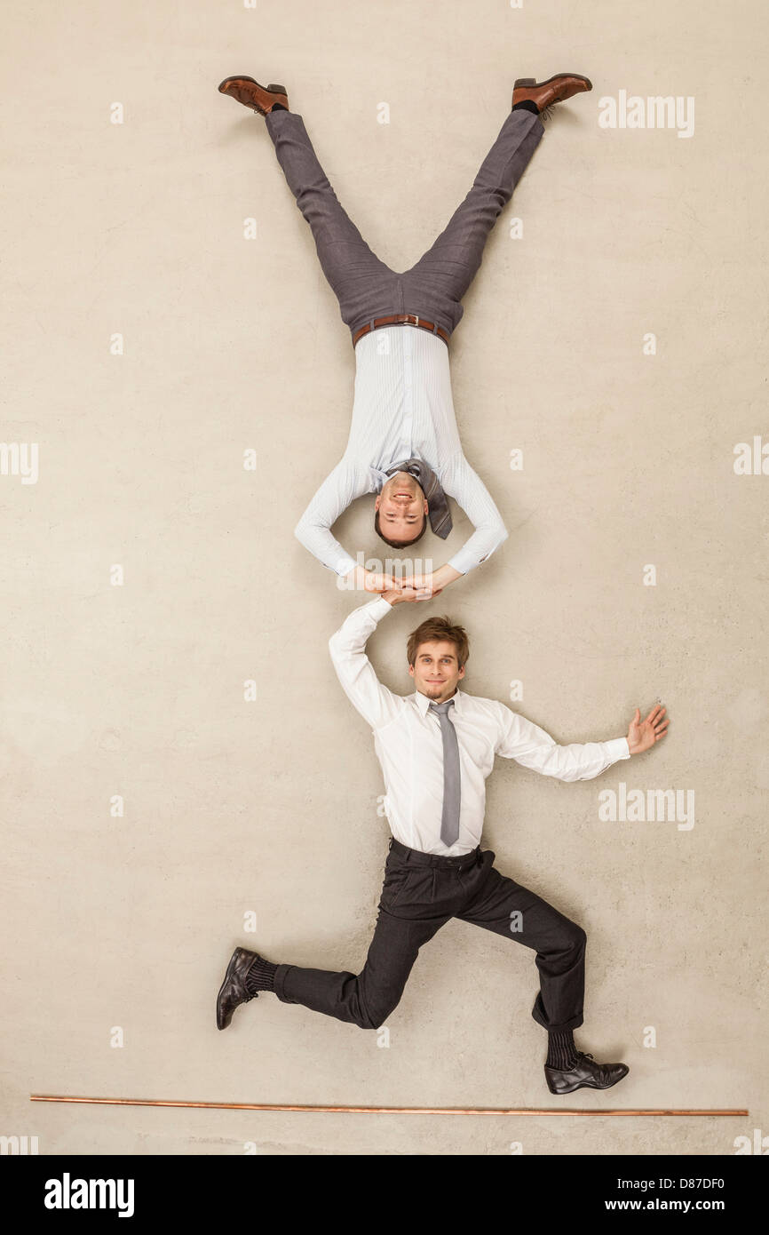 Businessmen with head to head position and holding hands against beige ...