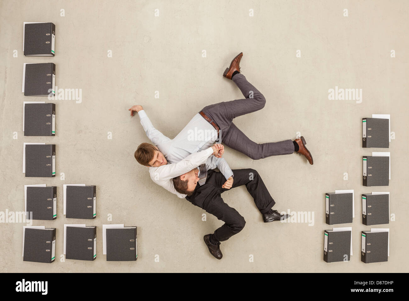Businessmen fighting in office between files Stock Photo - Alamy