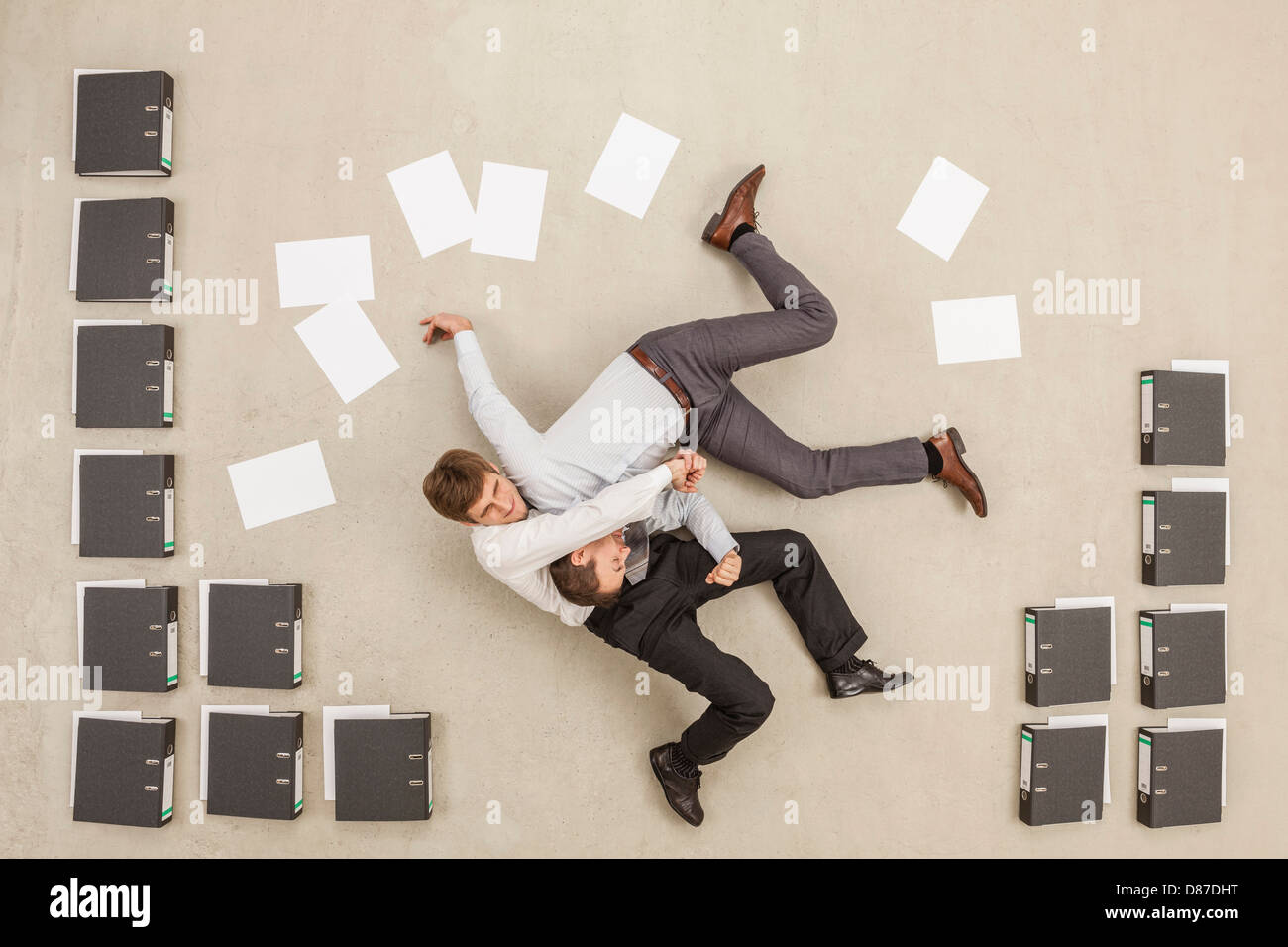 Businessmen fighting in office between files Stock Photo - Alamy