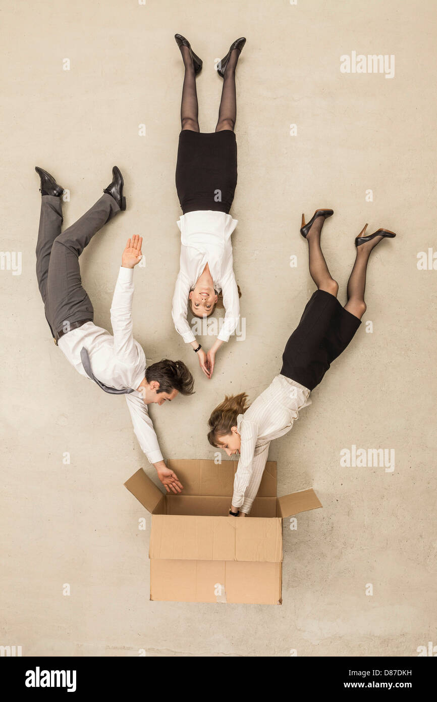 Business people getting inside box Stock Photo - Alamy