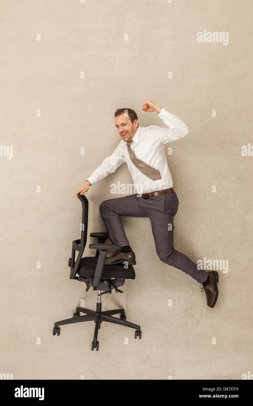 Businessman skating on office chair Stock Photo - Alamy