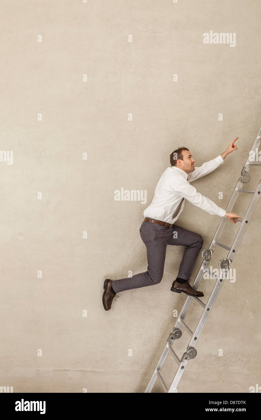 Businessman climbing ladder in office Stock Photo - Alamy
