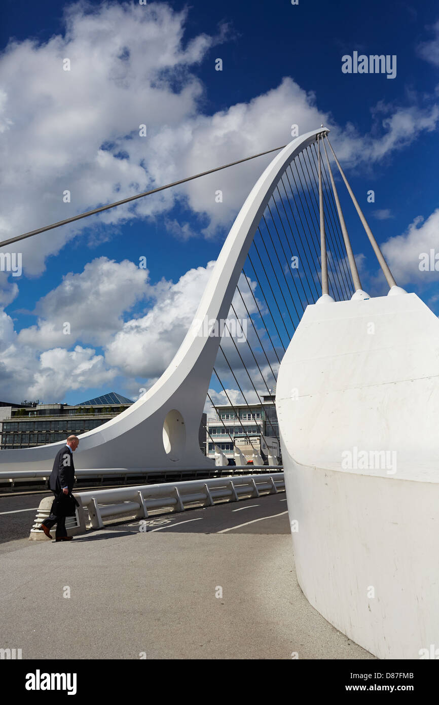 A Pedestrian crosses the Samuel Beckett Bridge which spans the river ...
