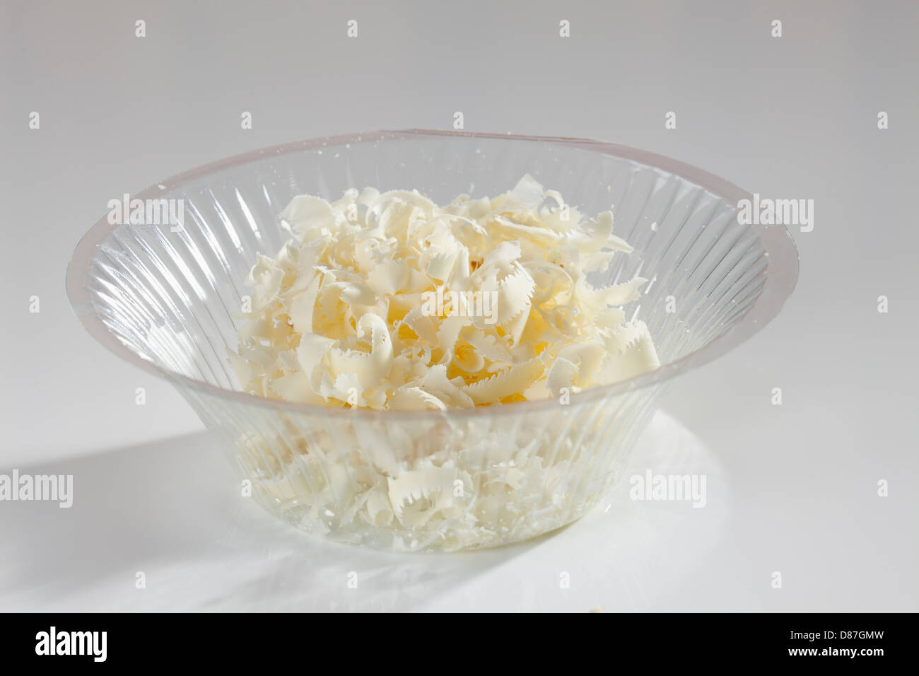 Bowl of white chocolate flakes on white background, close up Stock ...