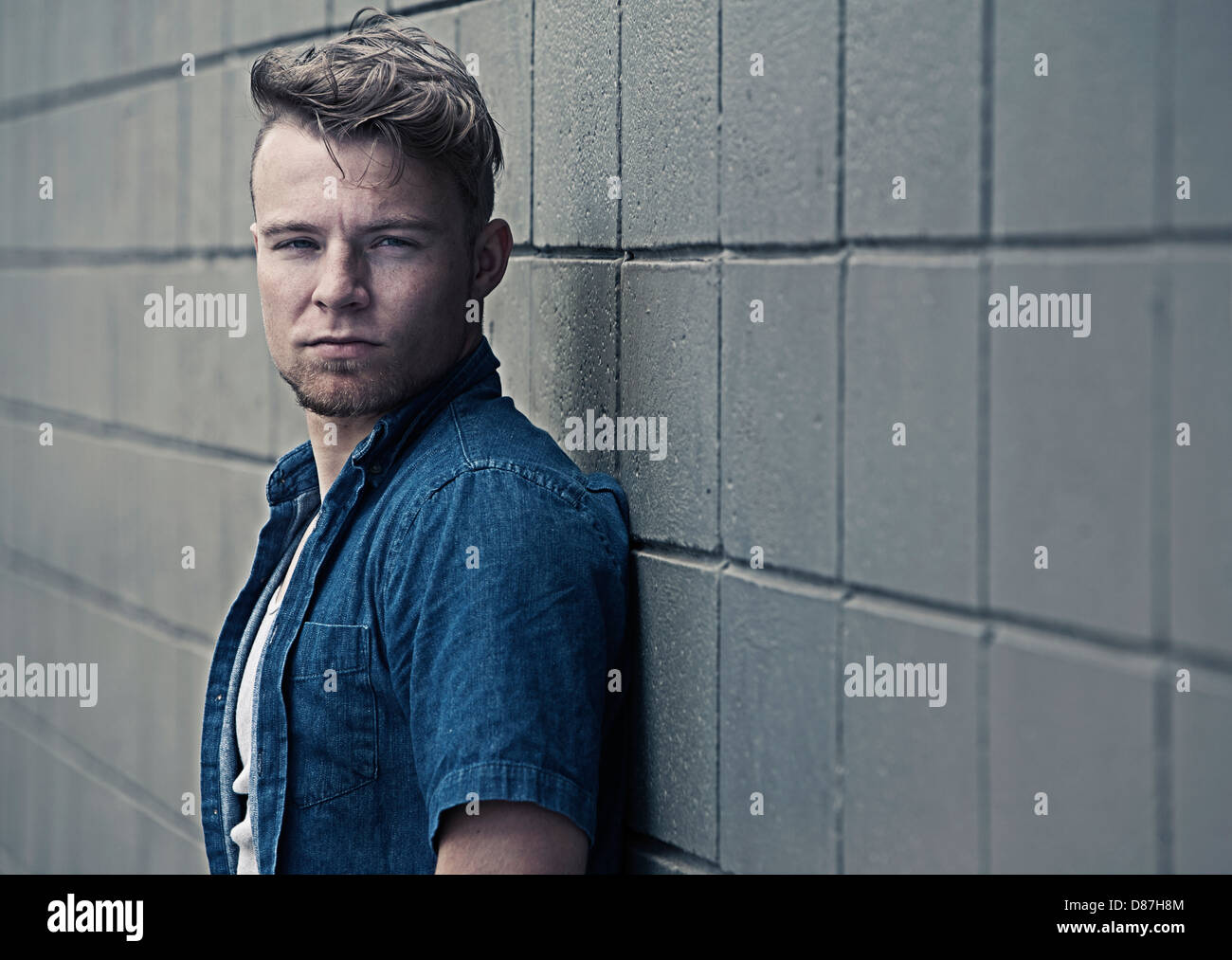 Man standing against block wall Stock Photo - Alamy
