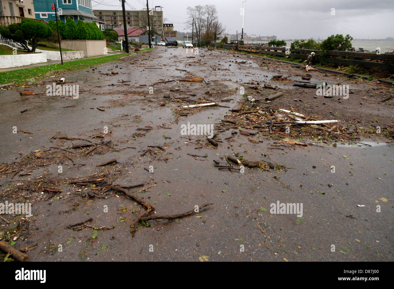 Sand, mud, boulders, seawater and flotsam washed over sea wall and into ...
