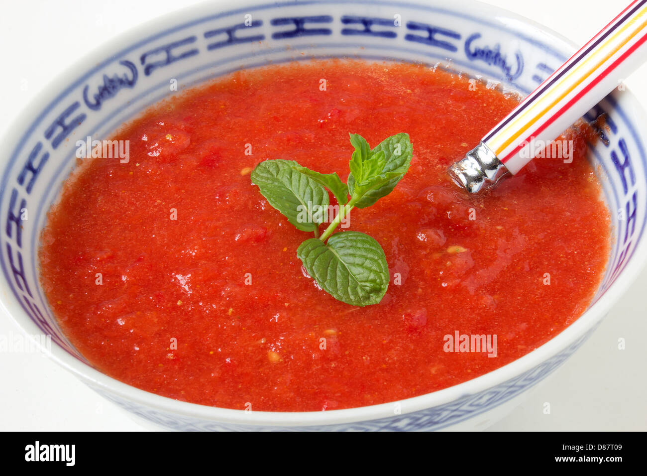 Red gazpacho made with tomatoes, papers and curry decorated with mint ...