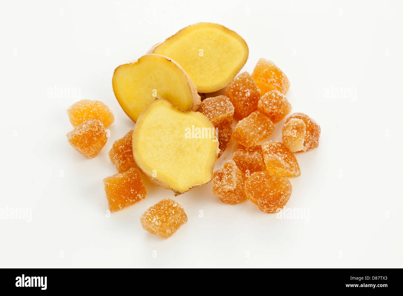 Sliced ginger and pieces of candied ginger on white background, close ...