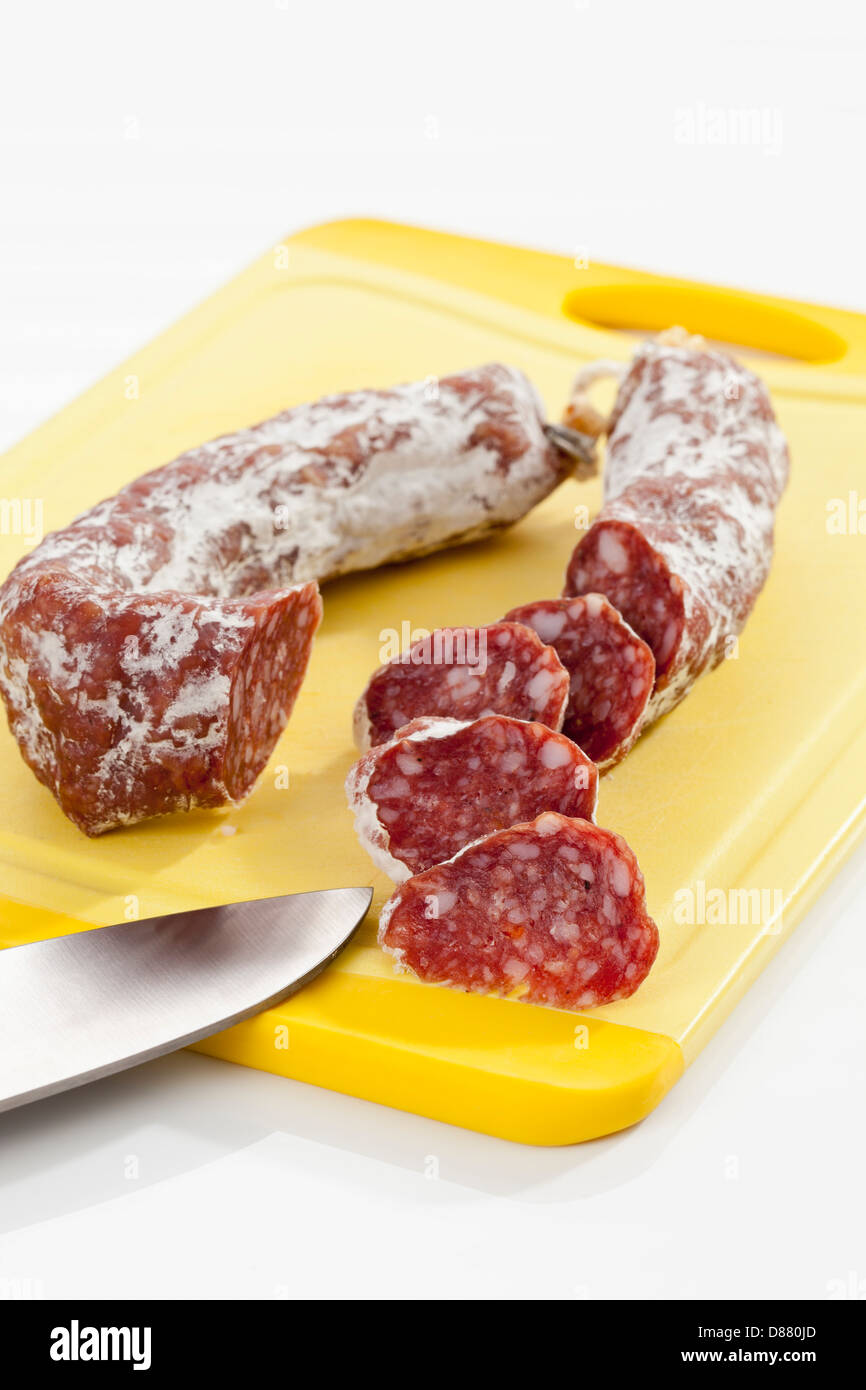 Salami on chopping board, close up Stock Photo - Alamy