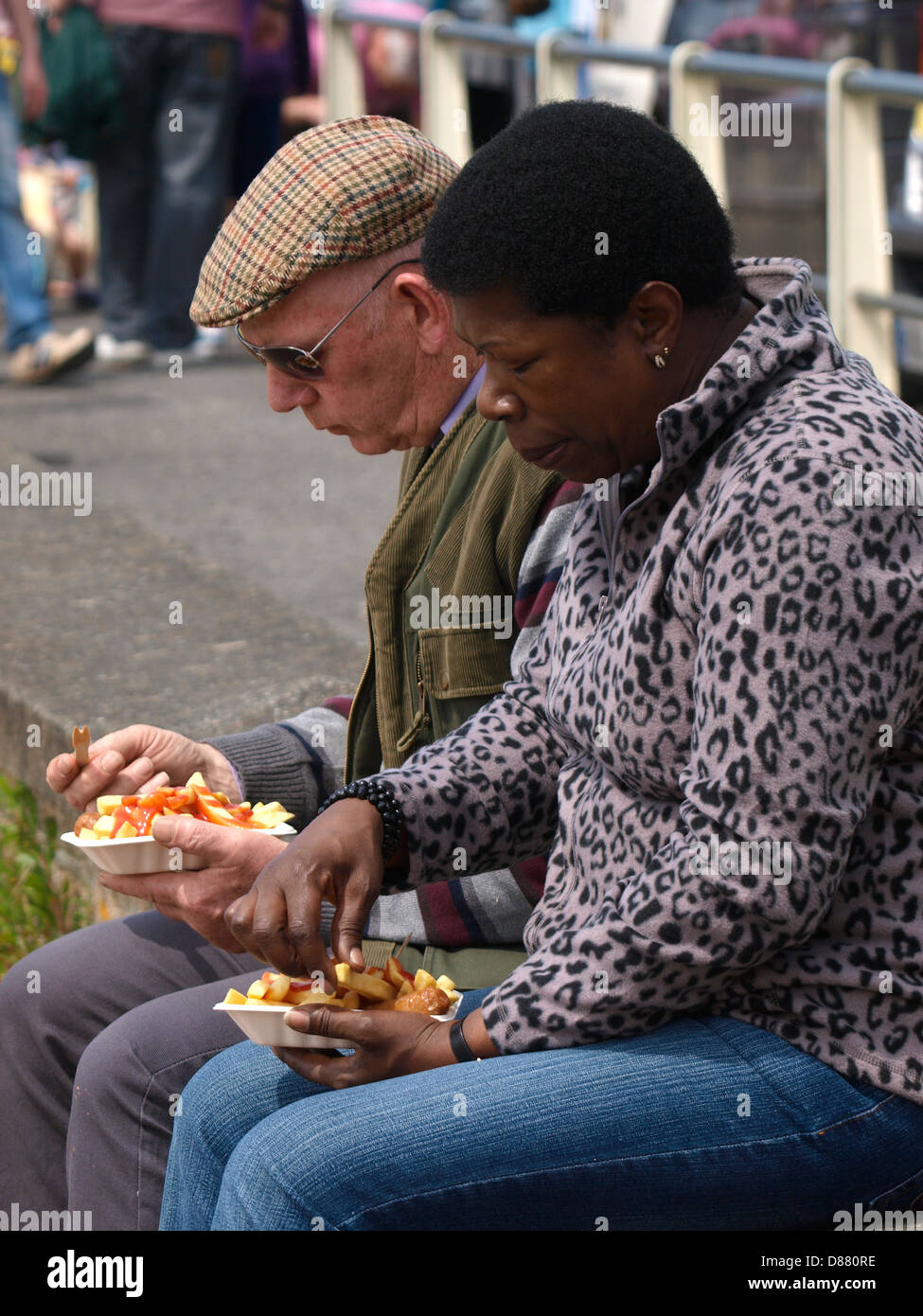 Mixed race couple eating take away chips, Barnstaple, Devon, UK 2013 ...
