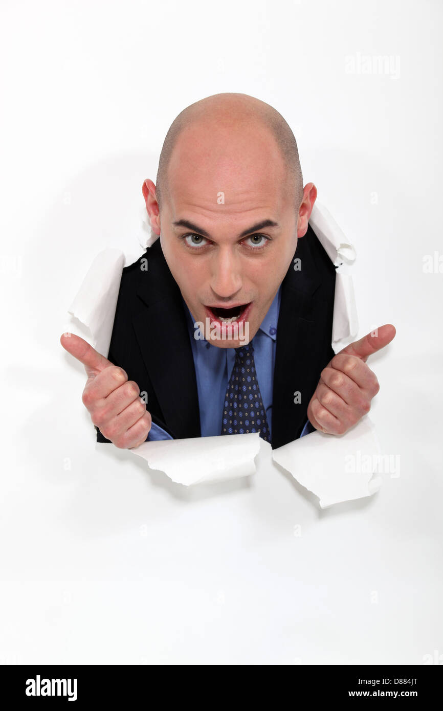 Man peeking through torn paper hole Stock Photo - Alamy