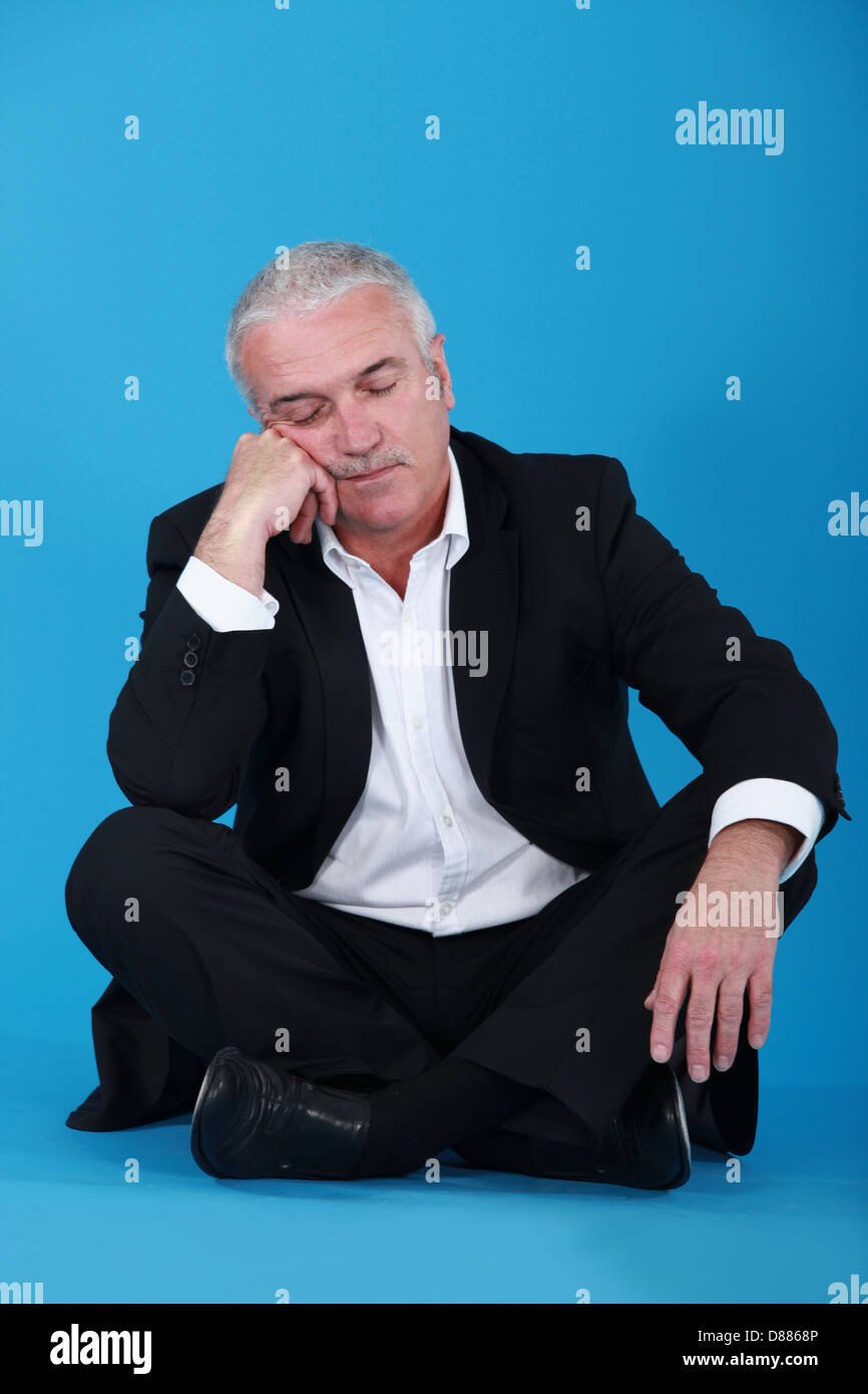 Man sitting cross-legged and falling asleep Stock Photo - Alamy