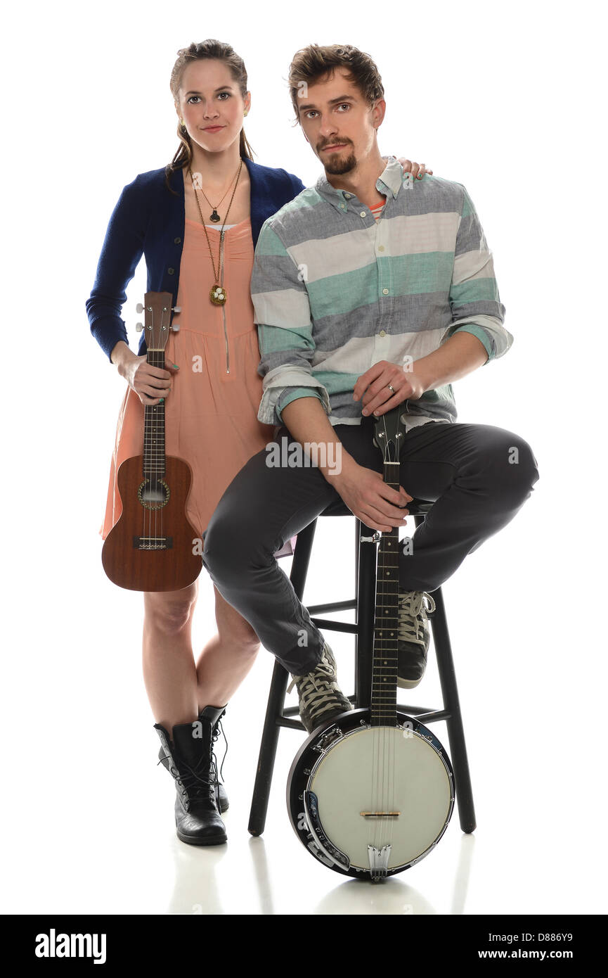 Young couple holding ucalaly and banjo isolated over white background ...