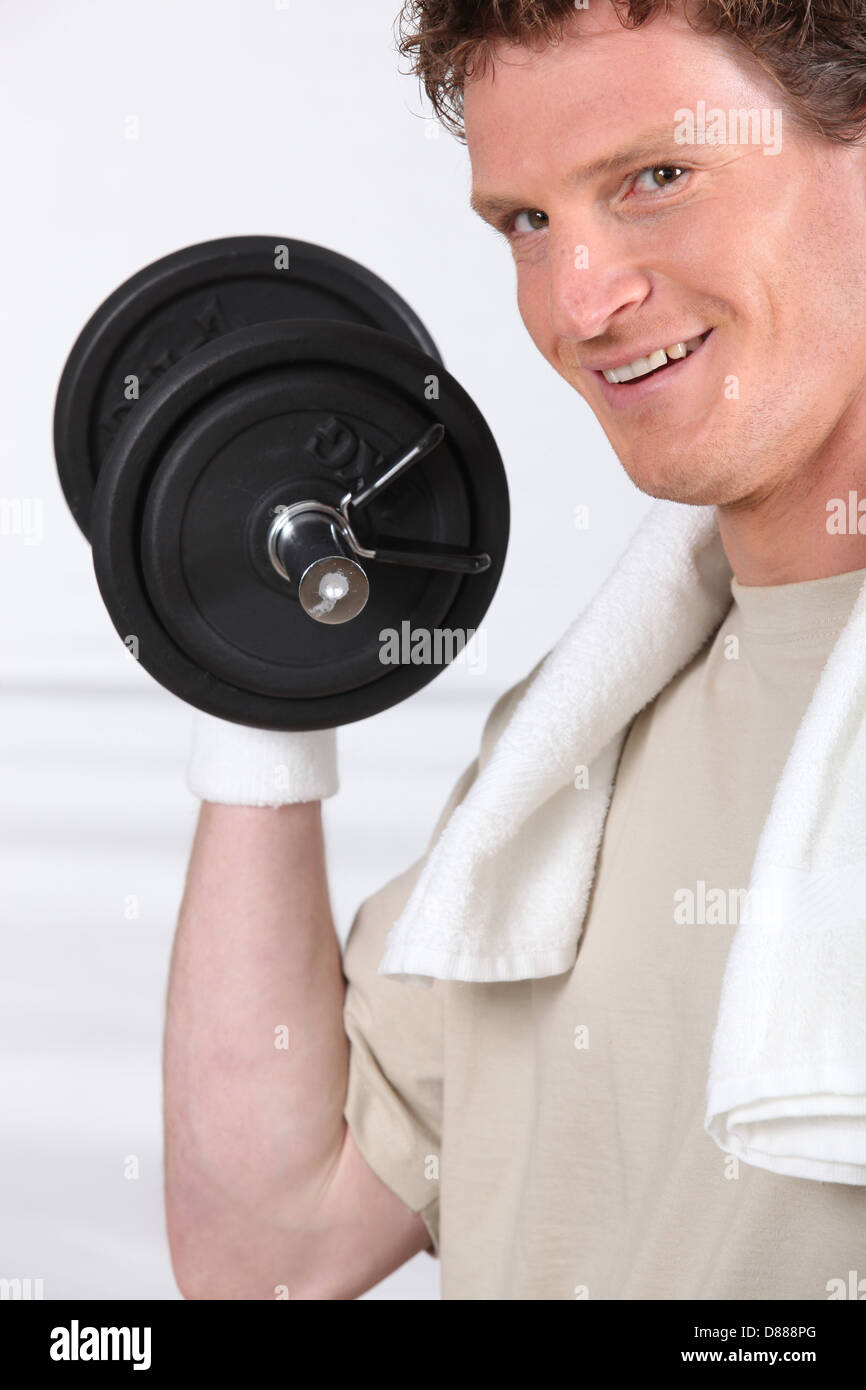 Smiling man lifting barbell on white background Stock Photo - Alamy