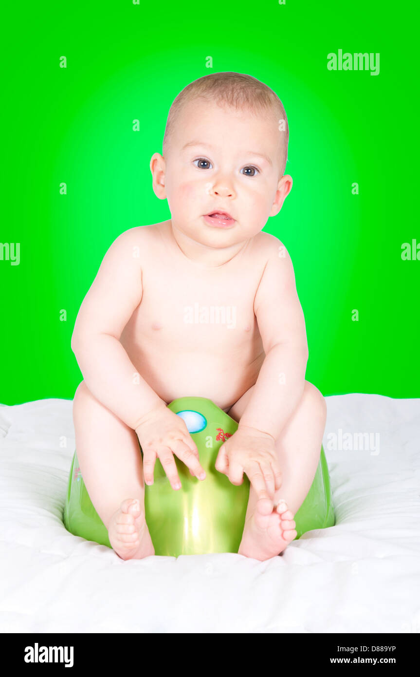 Baby siting on the green potty Stock Photo - Alamy
