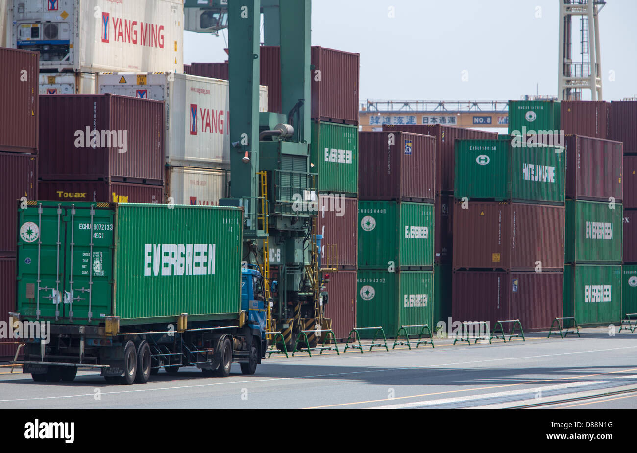 Tokyo, Japan - A truck drives past a pile of containers in cargo area ...