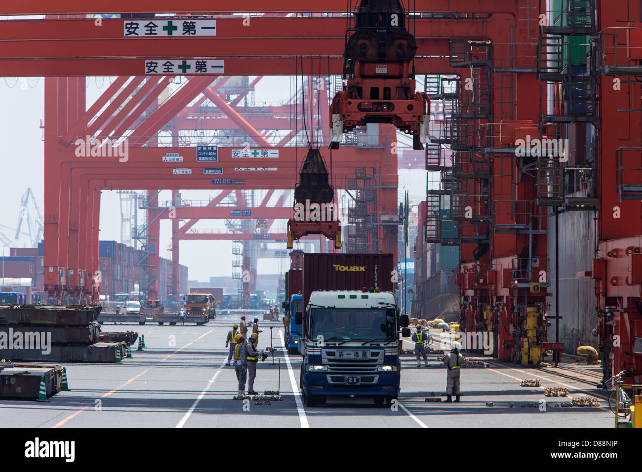 Tokyo, Japan - Workers manage containers from ship docked in cargo area ...