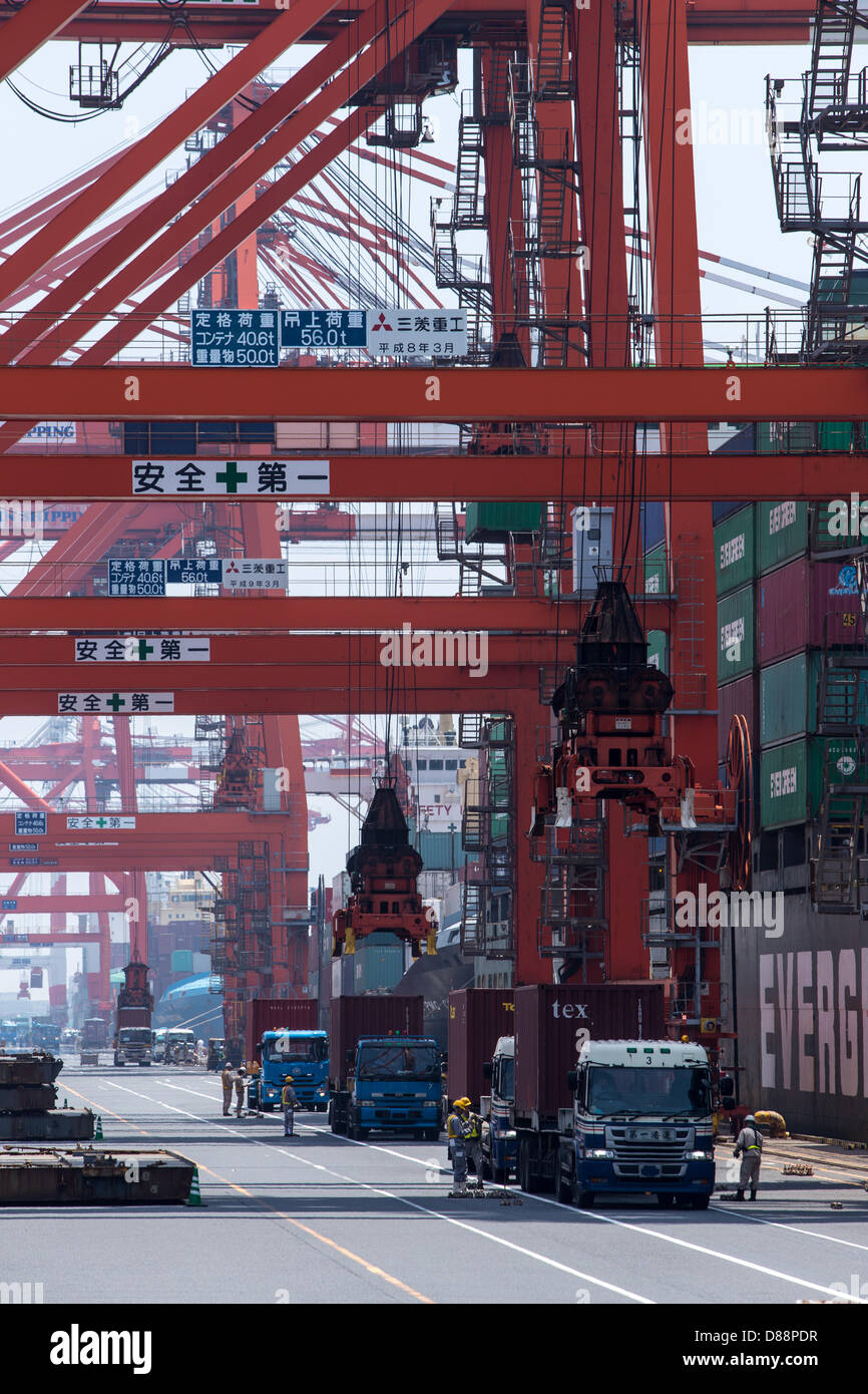 Tokyo, Japan - Workers manage containers from ship docked in cargo area ...