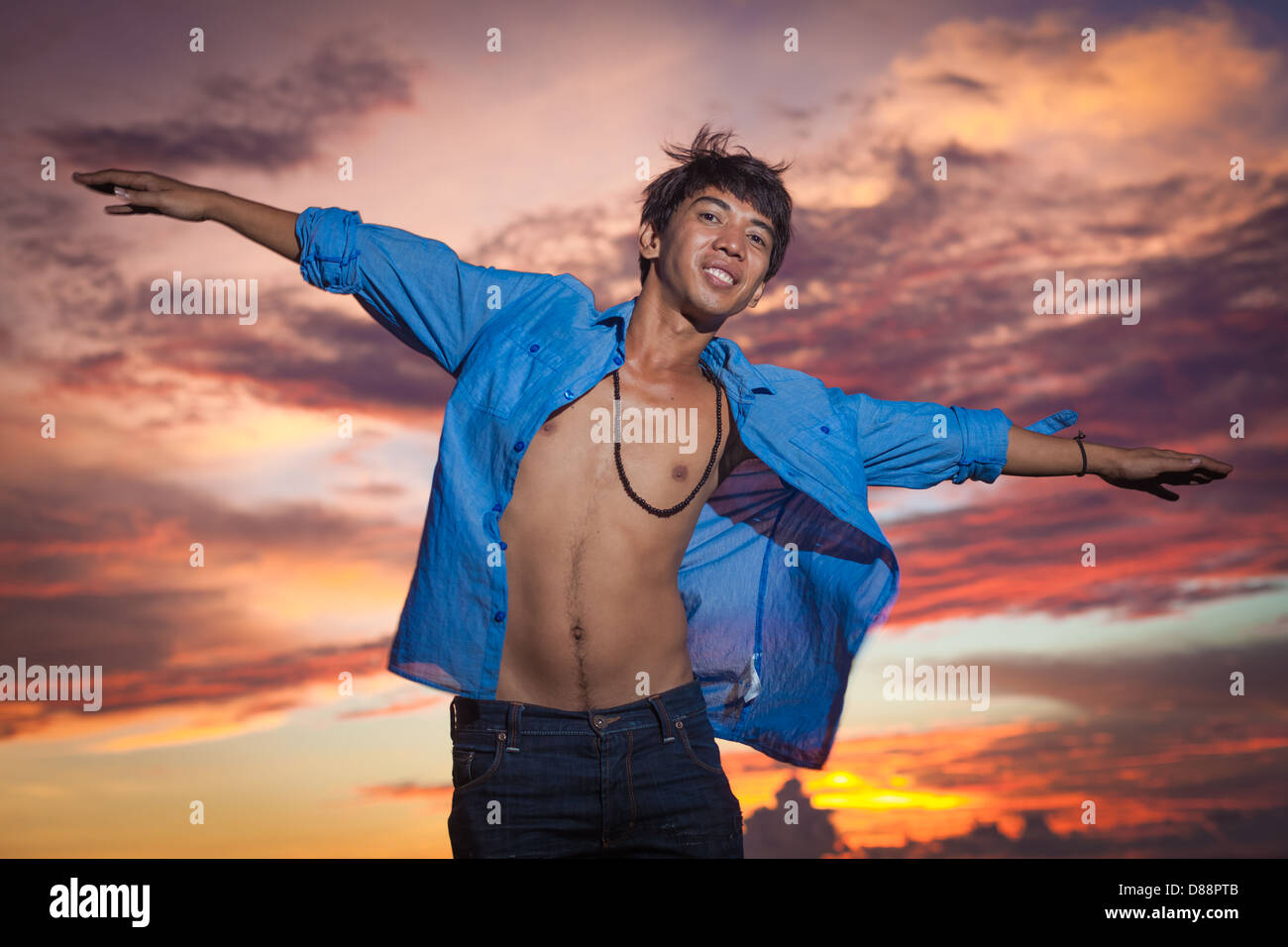 Young asian man jumping at sunset Stock Photo - Alamy