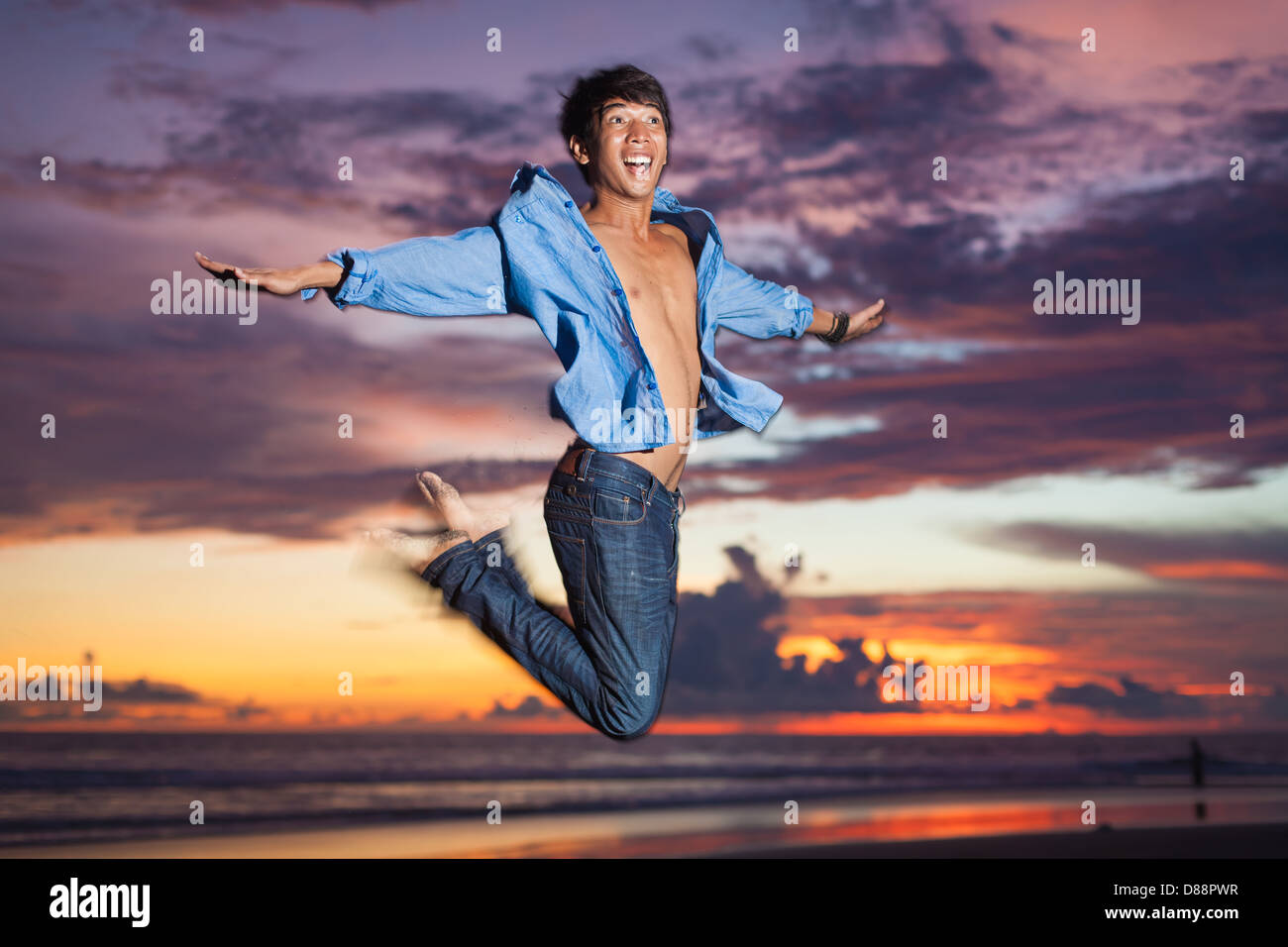 Young asian man jumping at sunset Stock Photo - Alamy