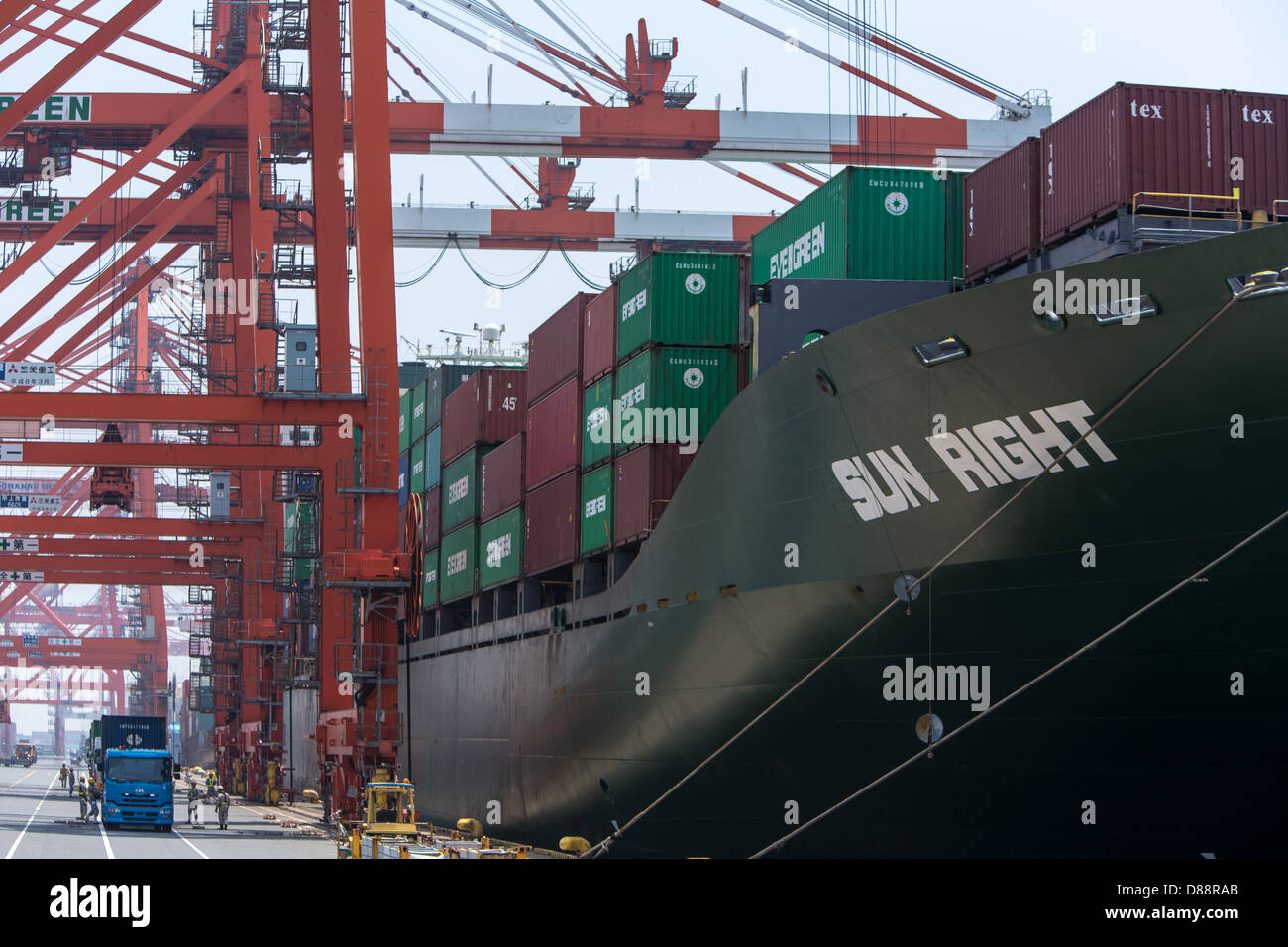 Tokyo, Japan - Workers manage containers from ship docked in cargo area ...