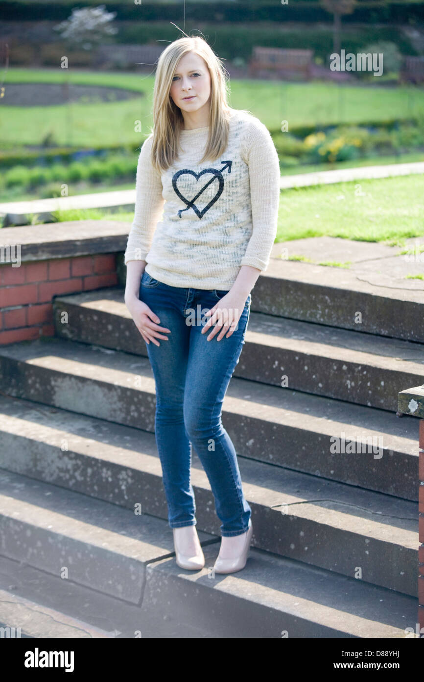 Pretty blonde girl standing on steps outside Stock Photo - Alamy