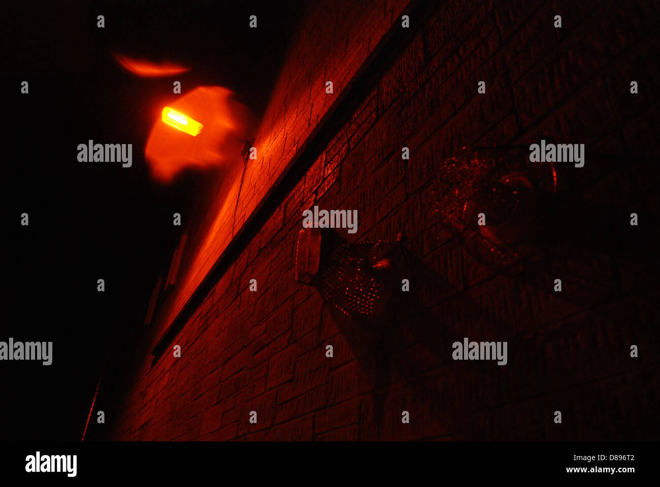 An orange light shining on the side of a building Stock Photo - Alamy