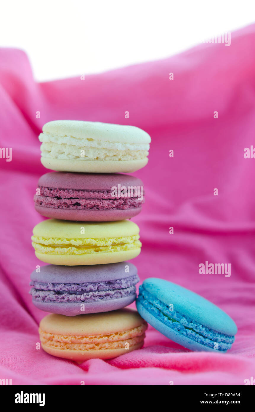 french macaroons stack on pink fabric over white background Stock Photo ...