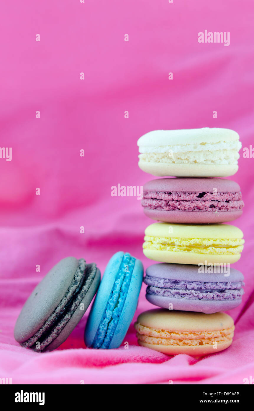 traditional colorful french macaroons stack on pink fabric background ...
