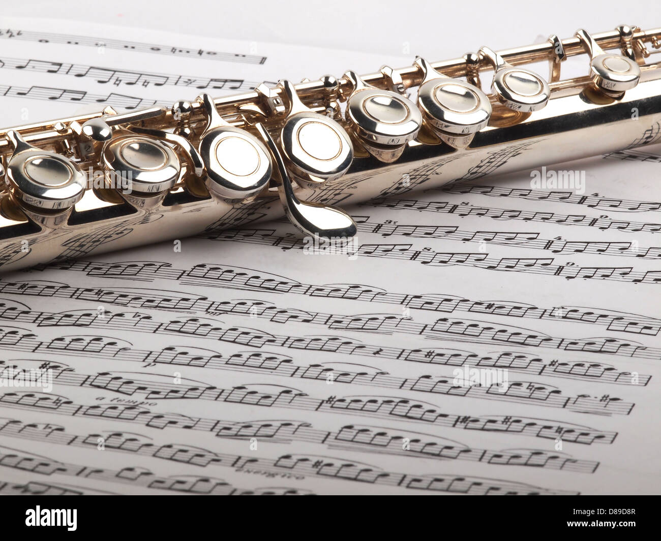 A used flute rests across an open etude musical score Stock Photo - Alamy