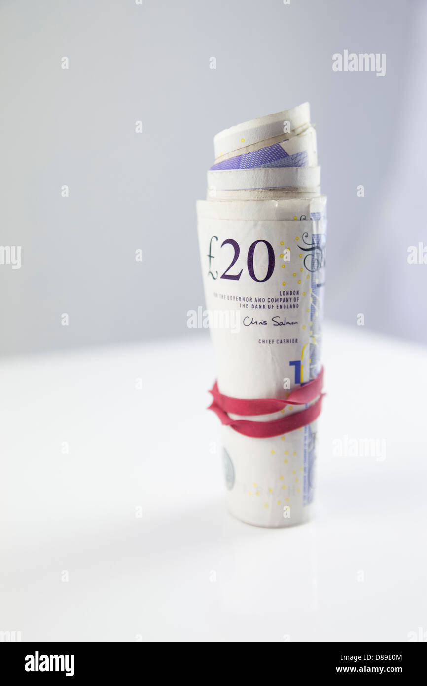 A roll of twenty pound notes on a table Stock Photo - Alamy