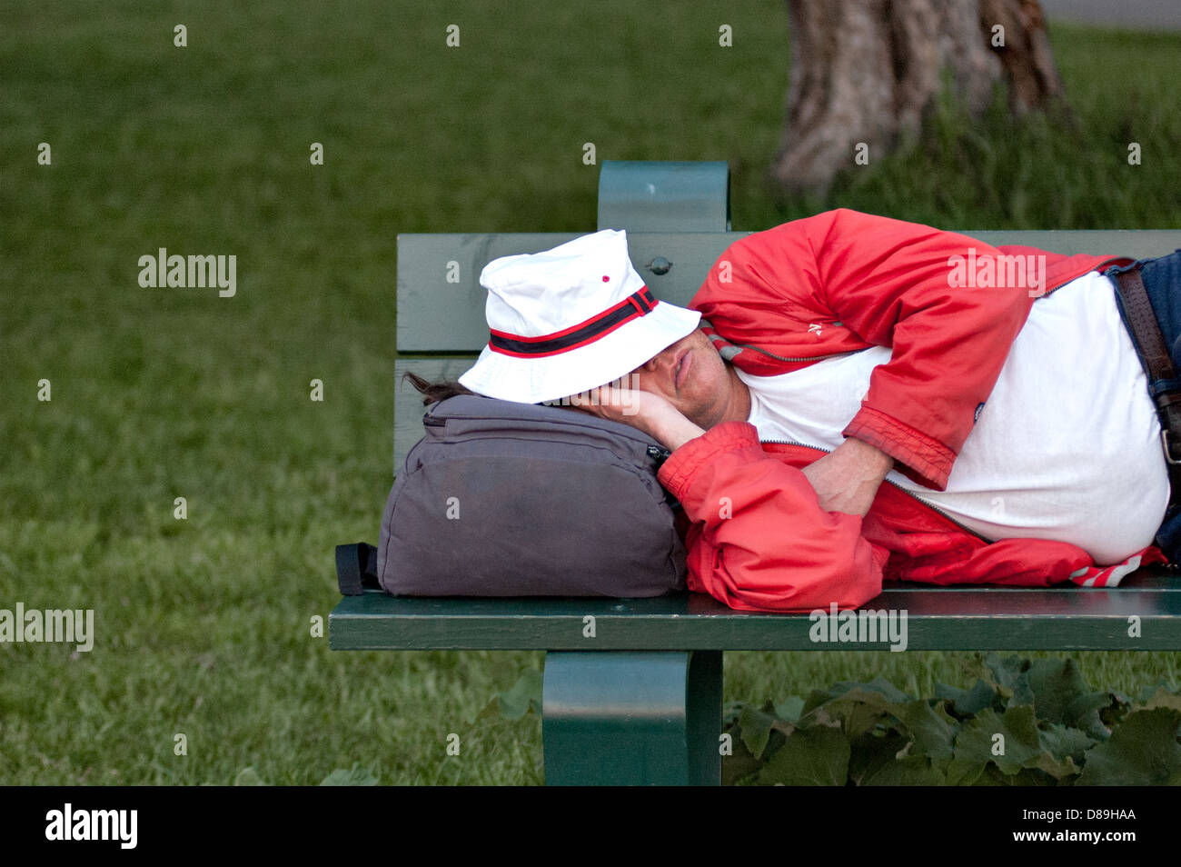 A man in a white hat catches a nap on a park bench Stock Photo - Alamy