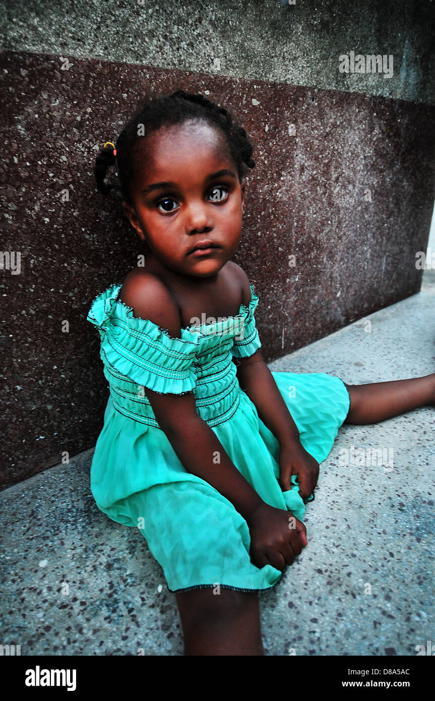Young Girl in Zanzibar sitting in the street with a clean dress Stock ...