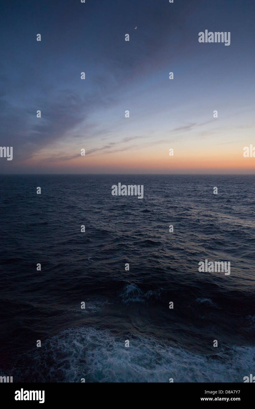 Moody seascape view, sunset, rising moon visible Stock Photo - Alamy