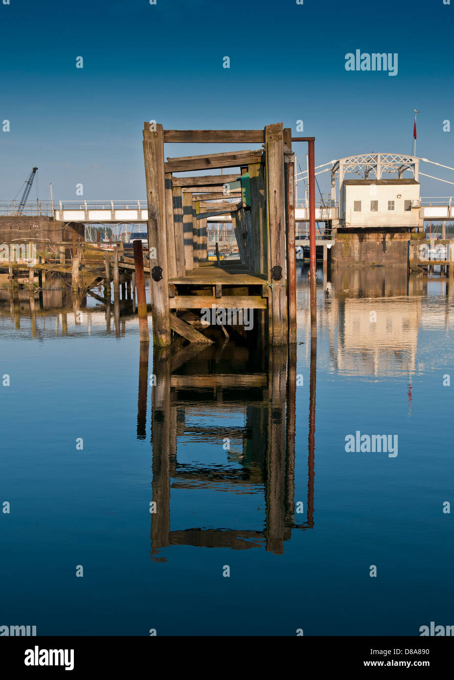 Wooden jetty mirrored reflection in the water Stock Photo - Alamy