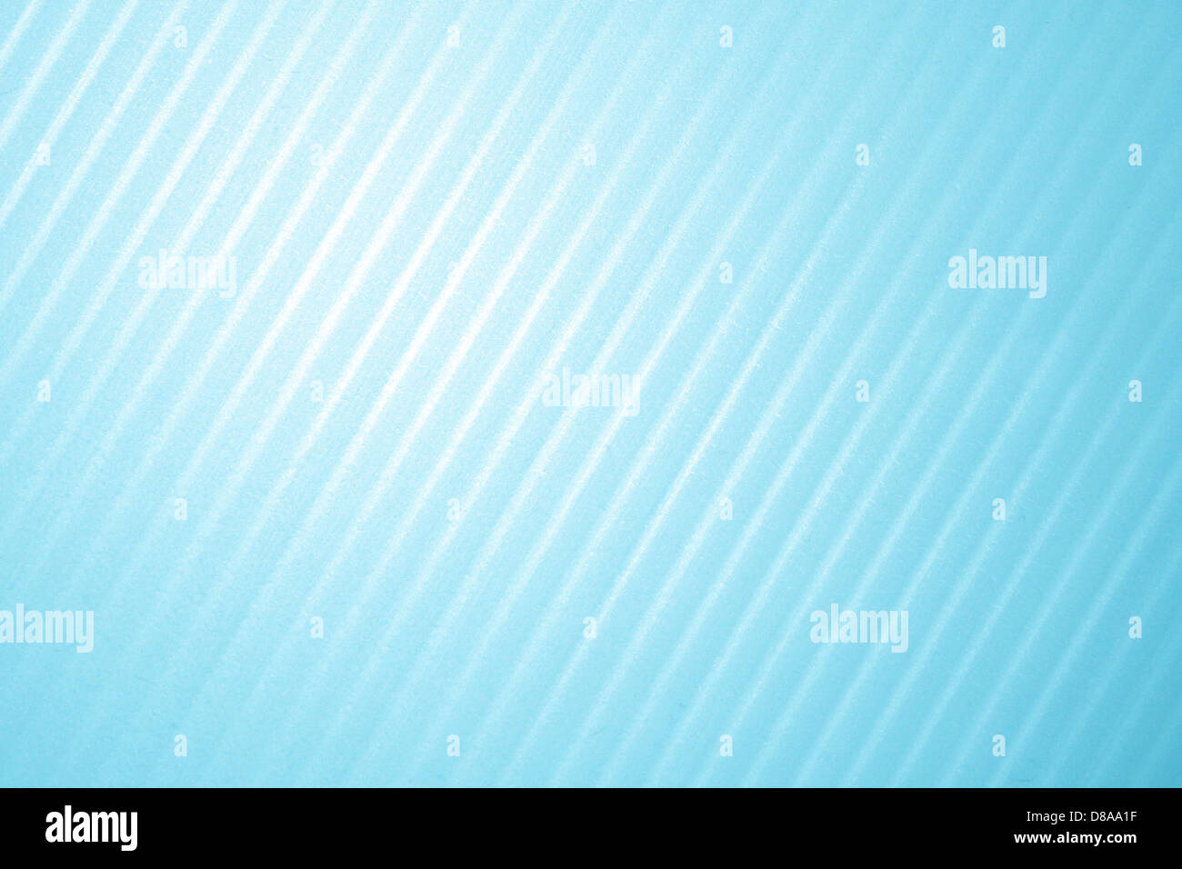 A close-up view of a baby blue plastic surface with diagonal stripes ...