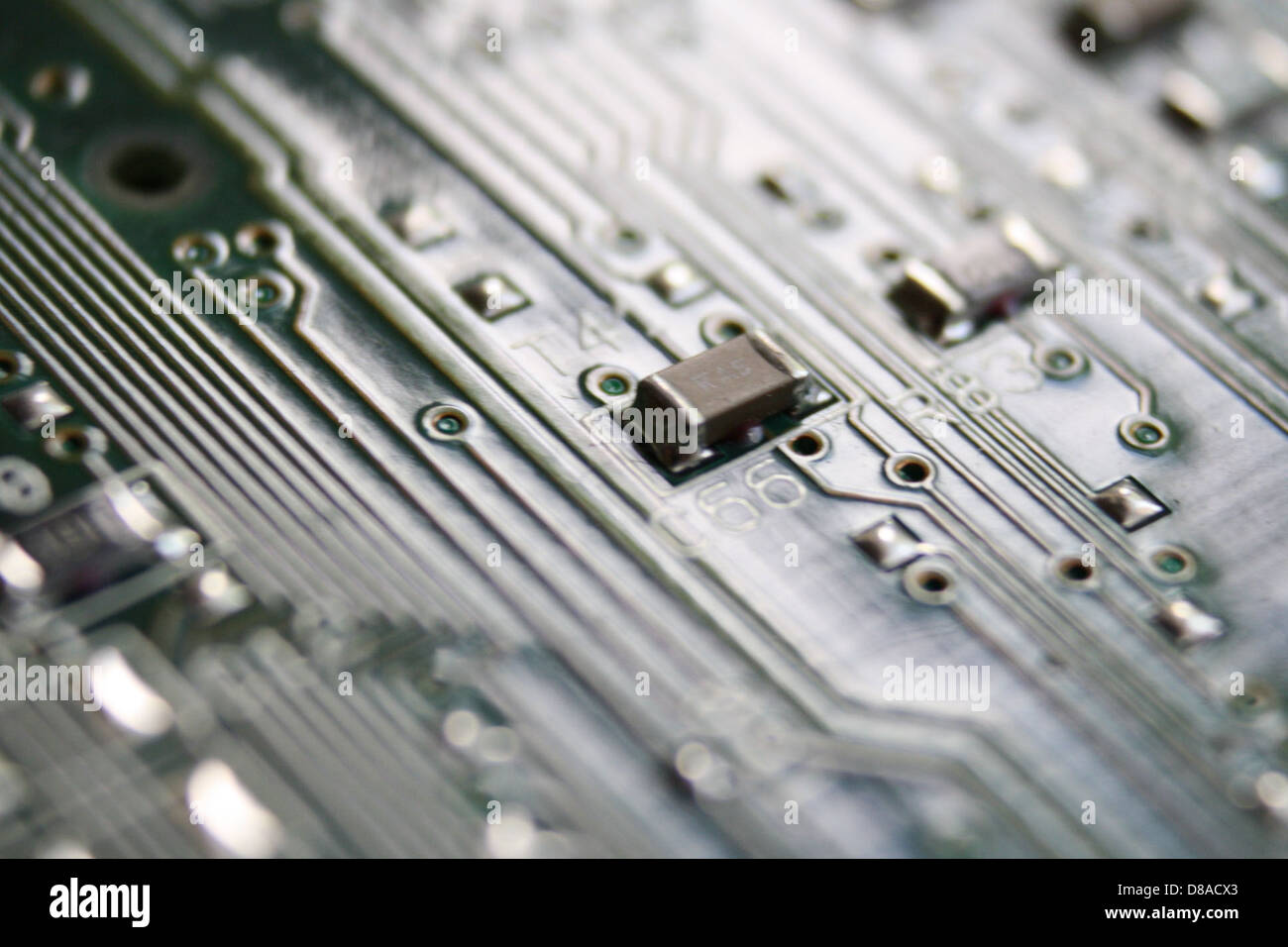 A close-up shot of a computer circuit board, revealing intricate pathways and electronic ...