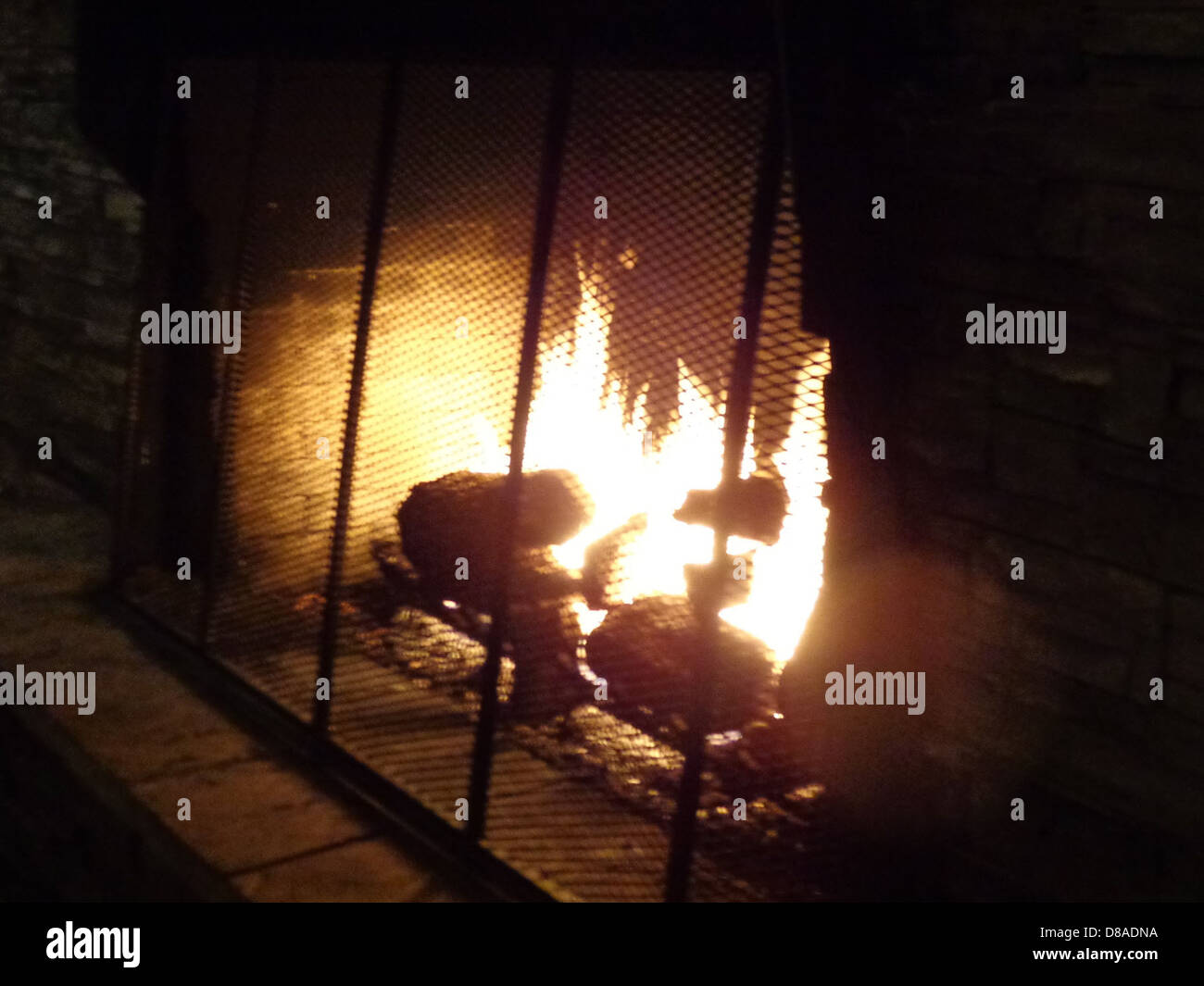 A cozy fire burning in a fireplace, emitting warm light and creating a ...